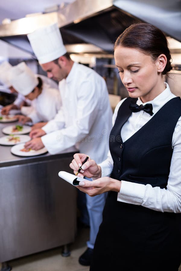 Waitress with Note Pad in Commercial Kitchen Stock Photo - Image of ...