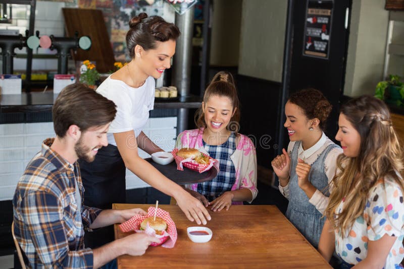 Waitress Serving Food To Customers in Restaurant Stock Photo - Image of ...