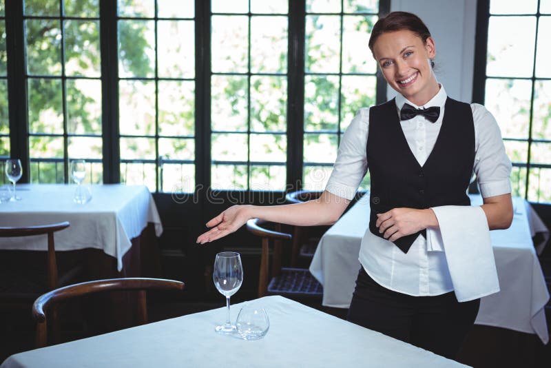 Waitress showing a table stock image. Image of glasses - 68237923
