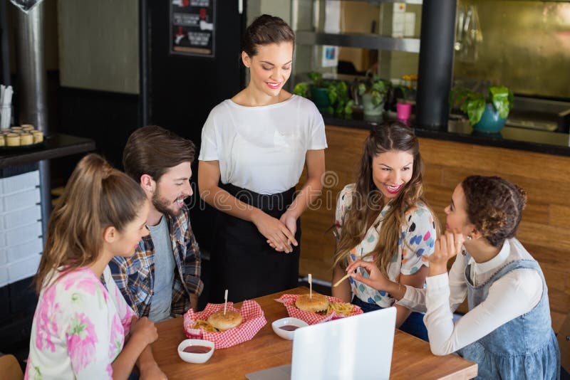 Waitress Standing by Customers in Restaurant Stock Photo - Image of ...