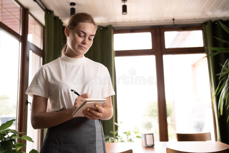 Waitress Writing an Order into a Notebook Working at Cafe. Stock Photo ...