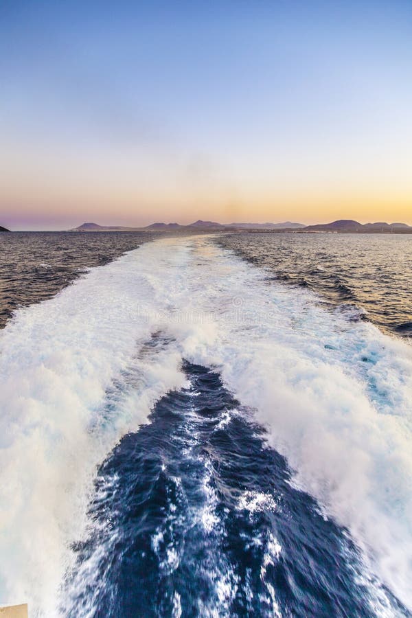 Wake Behind the Ship with an Island on the Horizon Stock Image - Image ...