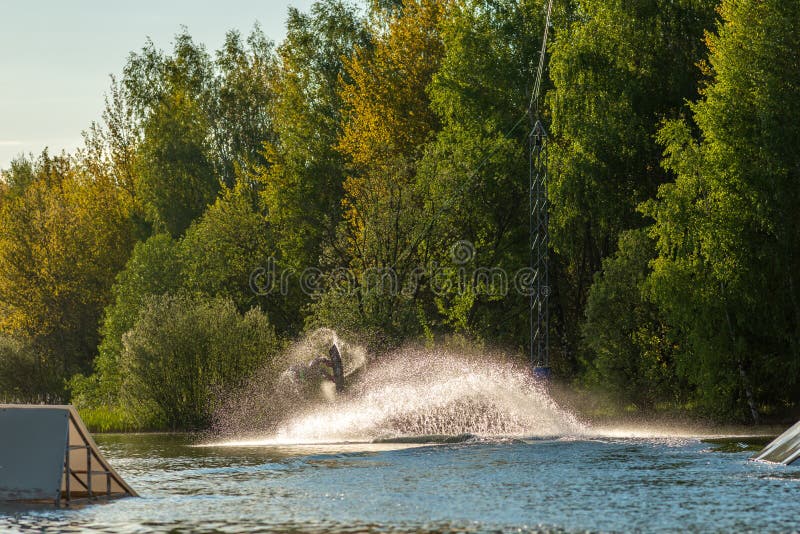Wakeboarder Making Tricks. Low Angle Shot of Man Wakeboarding on a Lake ...