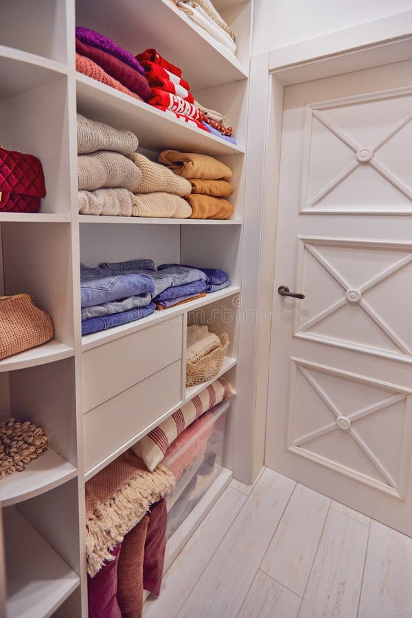 A Walk-in Storage Wardrobe with Clothing and Accessories on Shelves ...