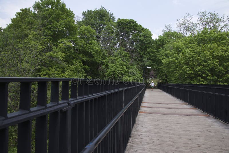 Walking Over the Pedestrian Bridge in Springtime. Using the Cell Phone ...