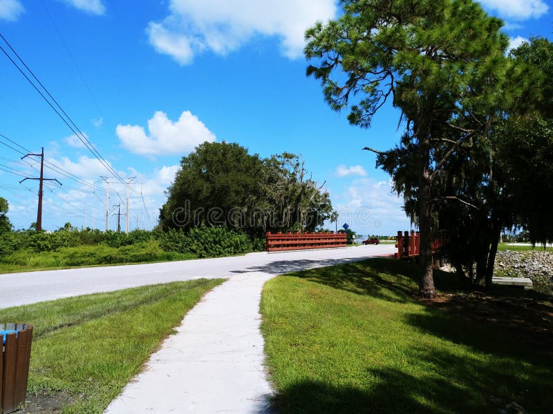 Walking Path Under a Bright Sunny Blue Sky with White Fluffy Clouds ...