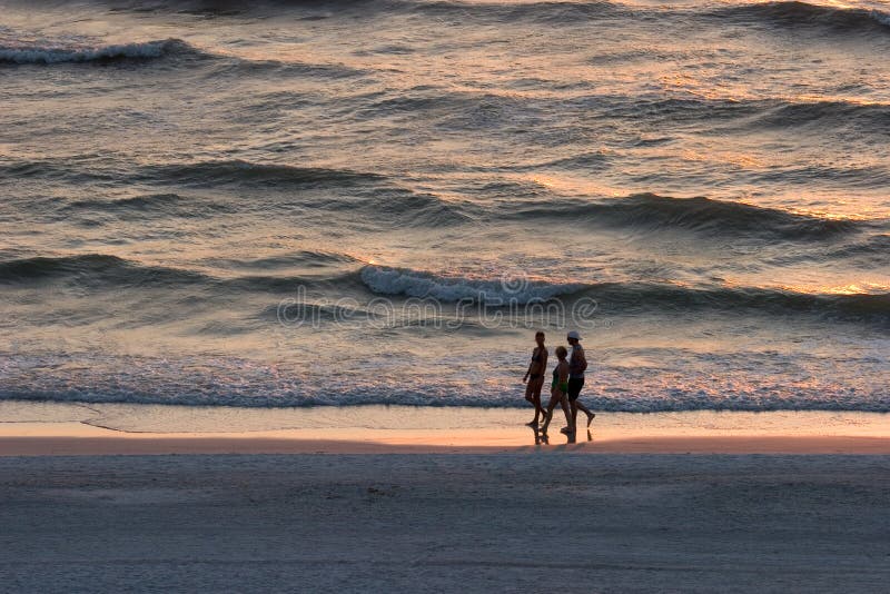 Walking at Sunset stock image. Image of group, coast, sunset - 1480763