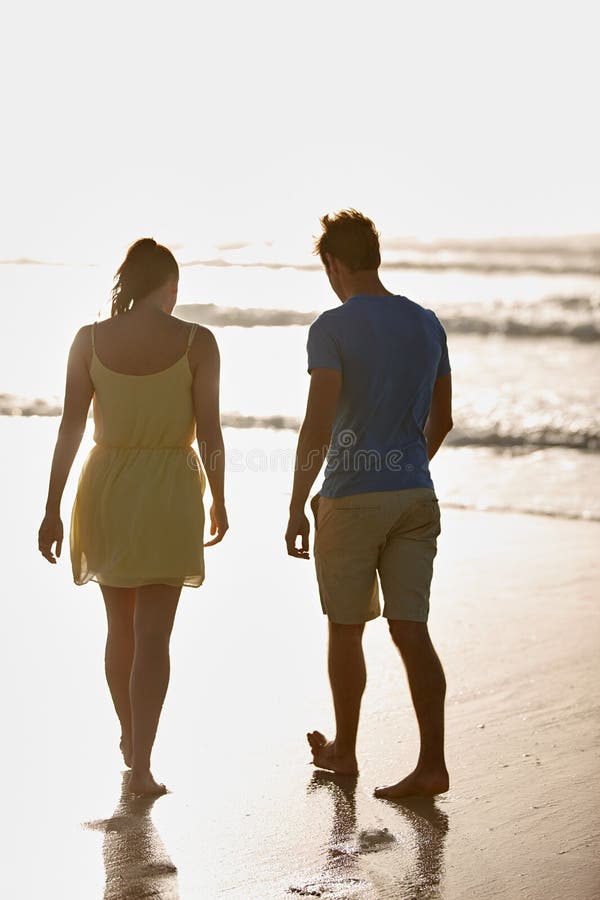 Walking into the Water. an Affectionate Couple Walking on the Beach ...