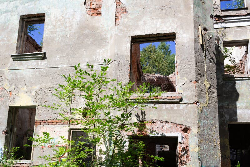 Wall of Abandoned Building with Broken Windows among Green Trees. Stock ...