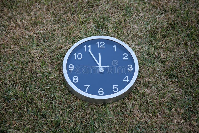 Wall clock in the grass stock photo. Image of late, metallic - 12689144