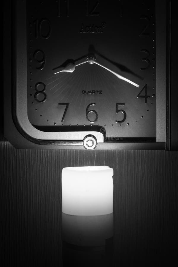 Wall clock lit by a candle stock image. Image of glow - 182363149