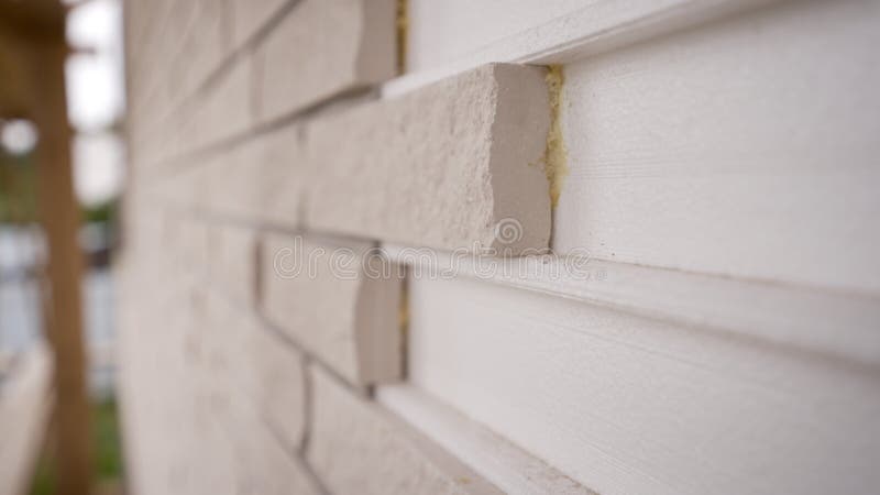 Wall Facing with Decorative Stone Tiles. Installation of a Stone on the ...