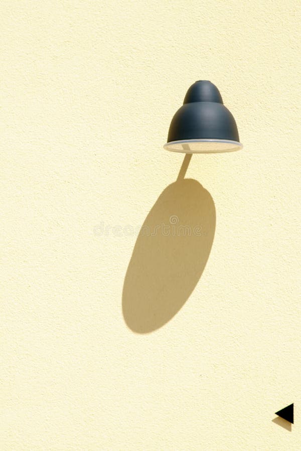 Wall lamp casts shadows stock photo. Image of arrow - 148781480