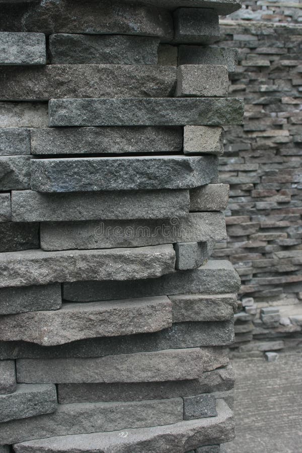 Wall of Layered Stones in a Rough Hewn Pattern with Wall in Background ...