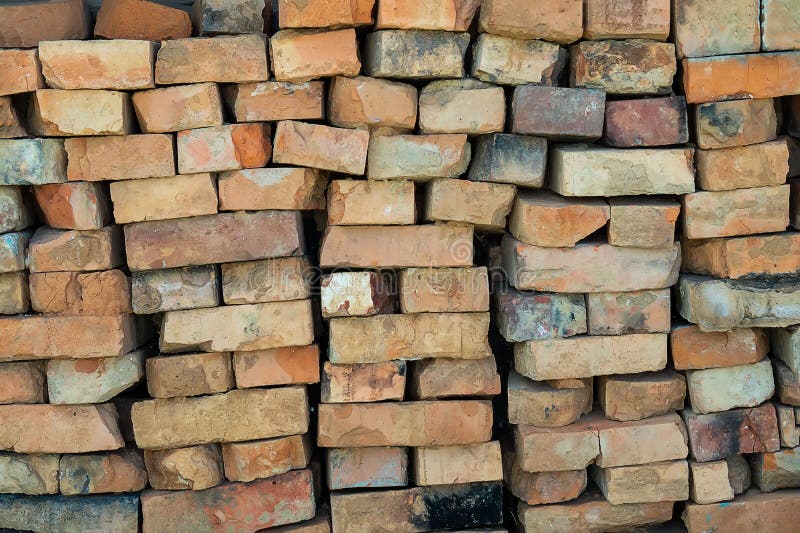 A Wall of Red and Orange Bricks Stacked in Rows Outside in the ...