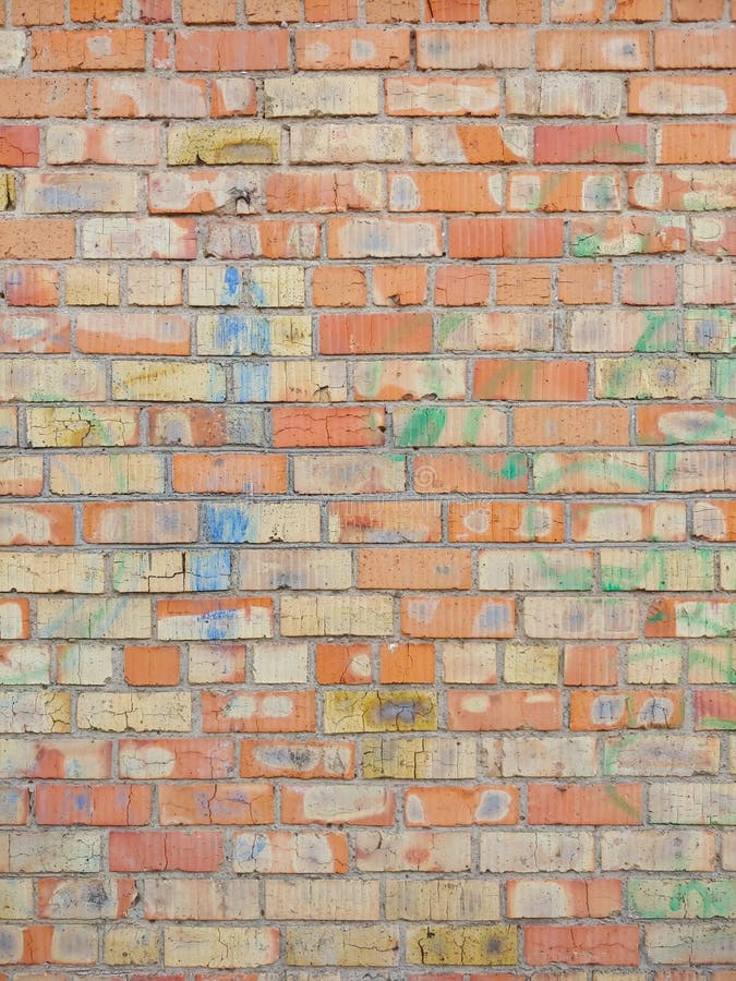 A Wall of Red and Yellow Bricks, Stained with Colored Paints. Stock ...