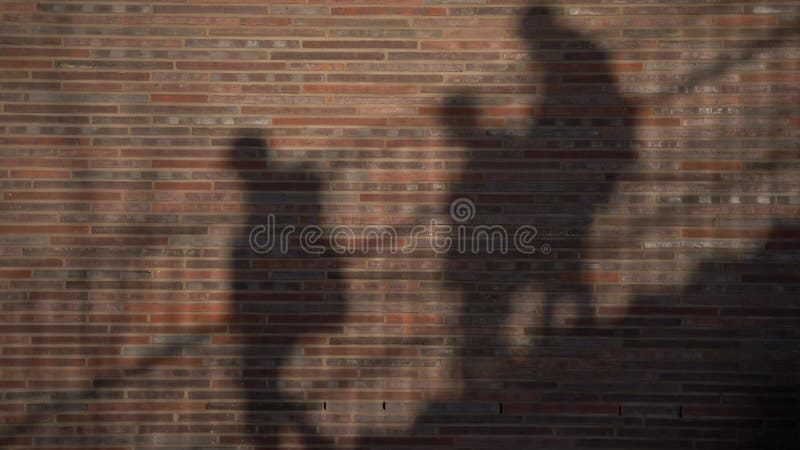 On the Wall the Shadow of Three People Go Down the Stairs. Stock ...