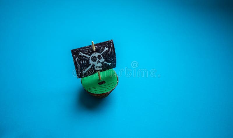 A Walnut Shell Boat with a Pirate Flag on a Blue Background. Stock ...
