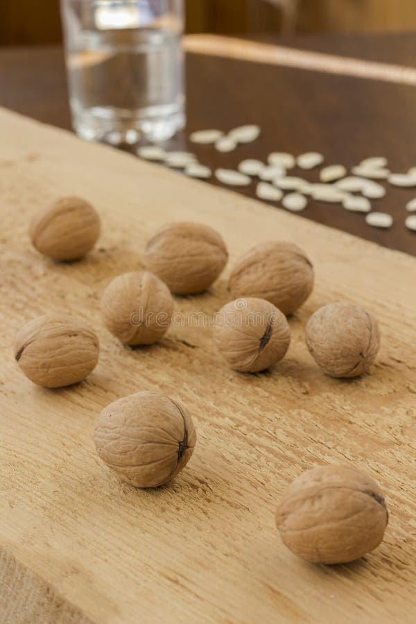 Walnuts on a Light Board and Pumpkin Seeds on a Dark Table. Glass of ...