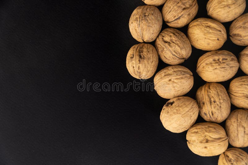 Walnuts in Shell on Black Surface, Top View. Background of Round ...