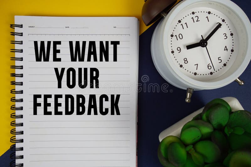 We Want Your Feedback Text Written on Notepad with Alarm Clock on Yellow and Navy Blue ...