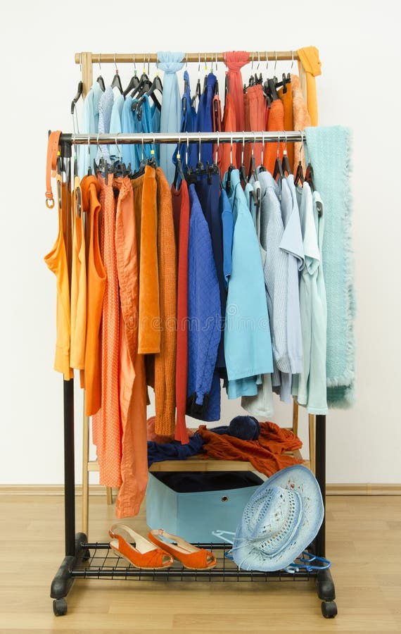 Wardrobe with Complementary Colors Orange and Blue Clothes on Hangers ...