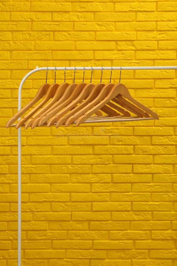 Wardrobe Rack with Many Hangers Near Yellow Brick Wall Stock Image ...
