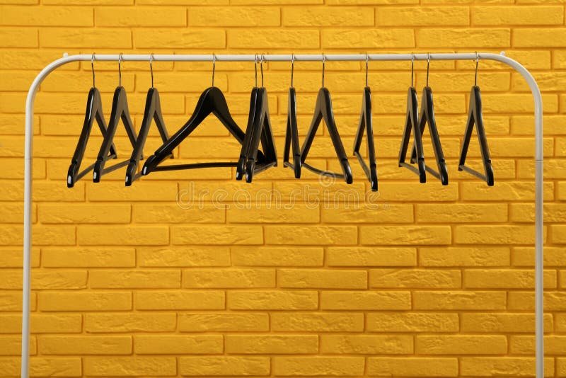 Wardrobe Rack with Many Hangers Near Yellow Brick Wall Stock Image ...