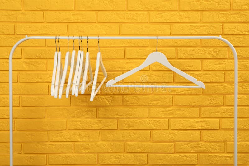 Wardrobe Rack with Many Hangers Near Yellow Brick Wall Stock Image ...