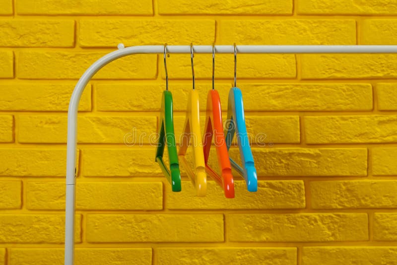 Wardrobe Rack with Many Hangers Near Yellow Brick Wall Stock Image ...