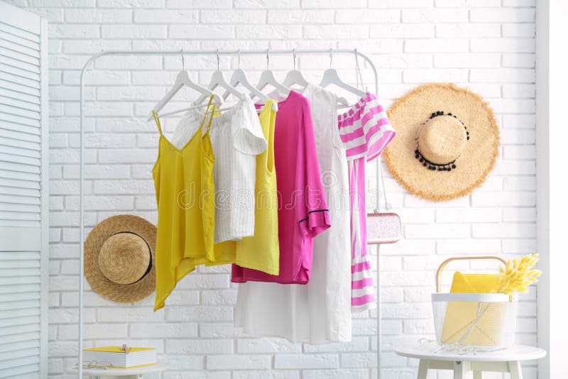 Wardrobe Rack with Women`s Clothes at Brick Wall in Room Stock Photo ...
