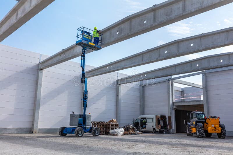 Warehouse Construction. Worker on Mobile Elavating Work Platform Stock ...