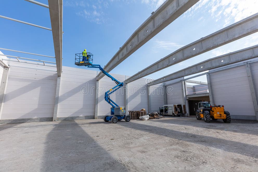 Warehouse Construction. Worker on Mobile Elavating Work Platform Stock ...