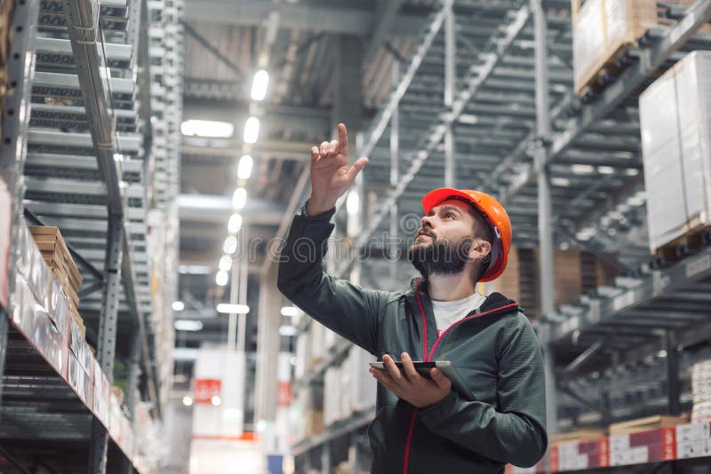Warehouse Manager Checking His Inventory in a Large Warehouse Stock ...
