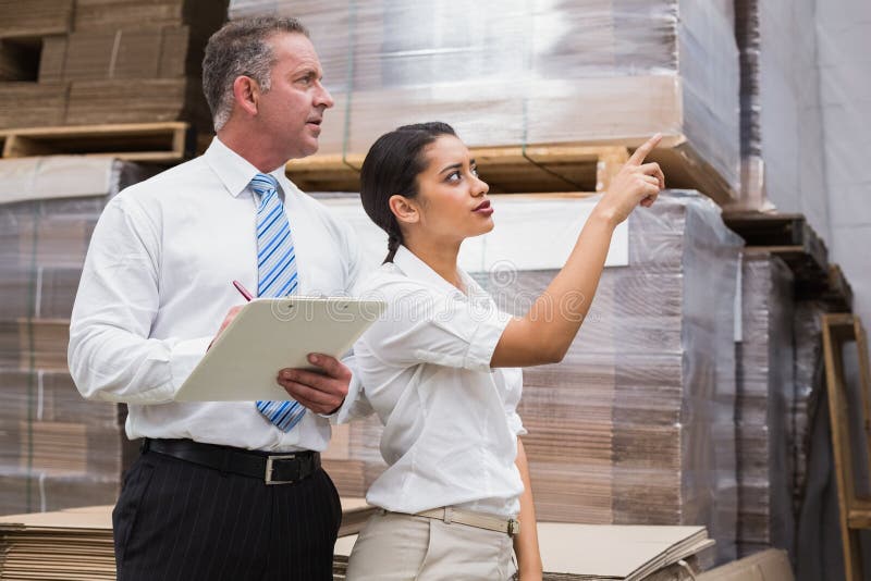 Warehouse Manager Checking His Inventory In A Large Warehouse Stock ...