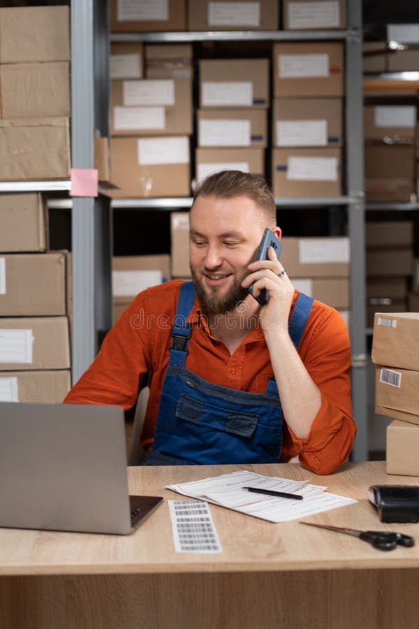 Warehouse Manager Talking Over Phone while Smiling Sitting with Laptop ...