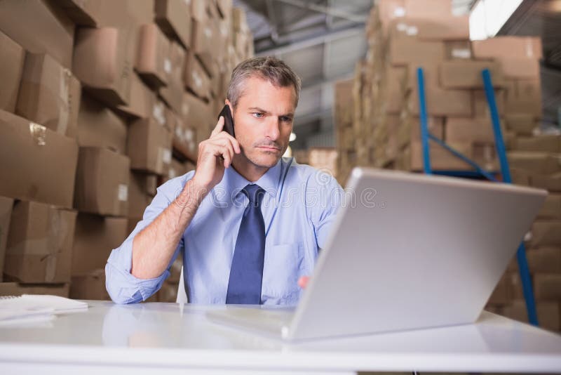 Warehouse Manager Using Cellphone and Laptop Stock Photo - Image of ...