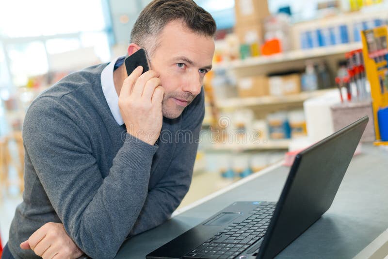 Warehouse Manager Using Telephone and Laptop at Desk Stock Image ...