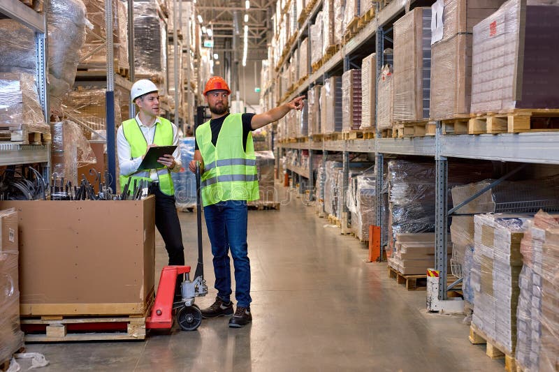 Warehouse Managers Walking through Large Warehouse Distribution Center ...