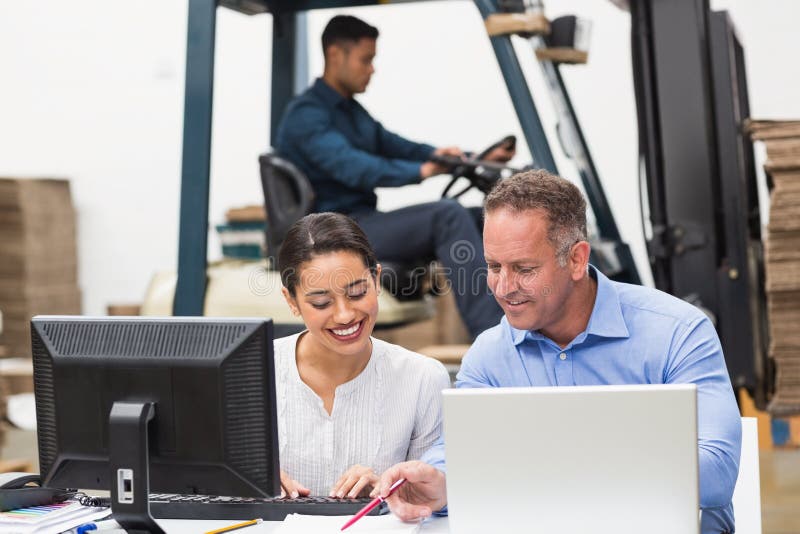 Warehouse Managers Working with Laptop at Desk Stock Photo - Image of ...