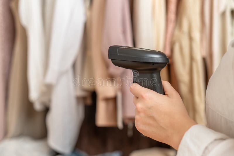 A Warehouse Woman Employee Accepts Clothes Using Barcode Scanner. Stock ...