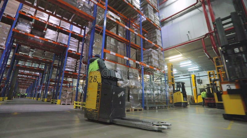 Warehouse Work. Modern Loaders in a Large Warehouse. Workflow in a ...