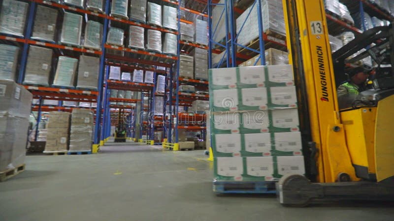 Warehouse Work. Modern Loaders in a Large Warehouse. Workflow in a ...
