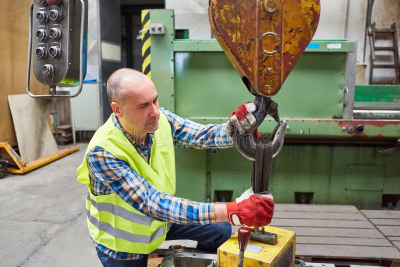 Warehouse Worker Attaches Load To Crane Hook in Warehouse Stock Image ...