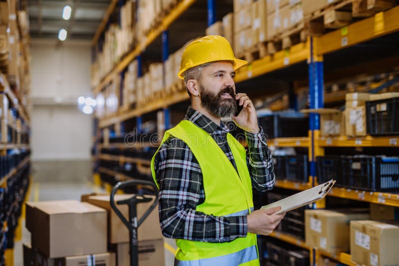 Warehouse Worker Calling and Checking Up Stuff in a Warehouse. Stock ...