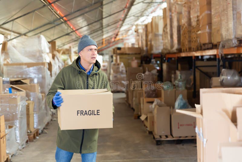 Warehouse Worker Carrying Boxes on Racks in in Warehouse Stock Photo ...