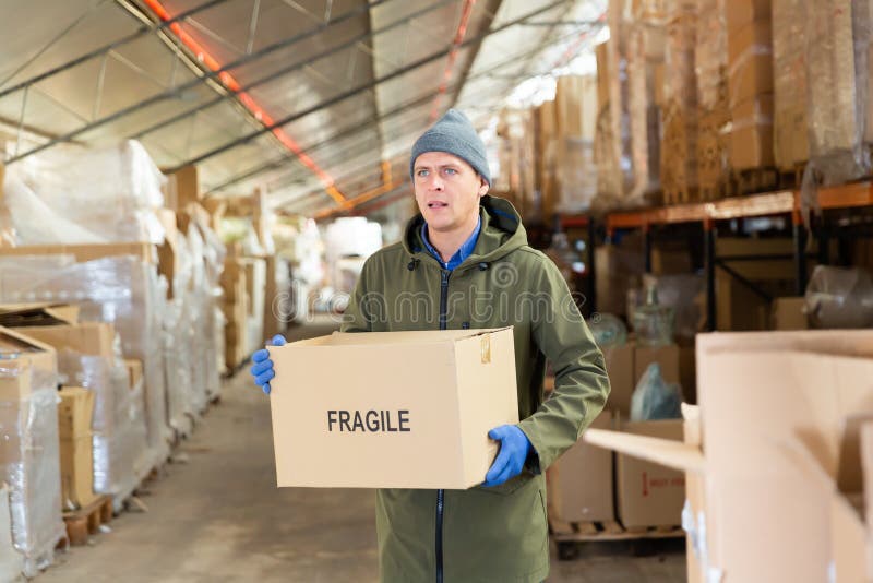 Warehouse Worker Carrying Boxes on Racks in in Warehouse Stock Photo ...