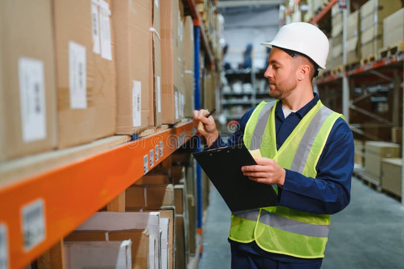 Warehouse Worker Checking His List on Clipboard in a Large Warehouse ...