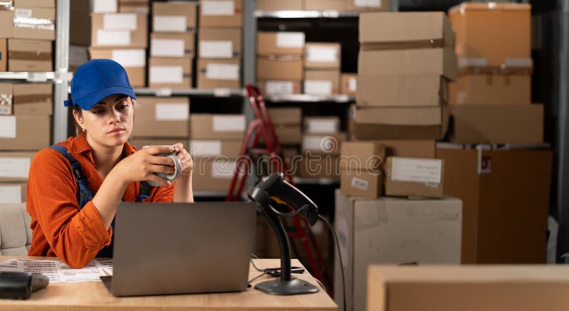 Warehouse Worker Drinking Tea or Coffee Working in Storeroom with Rows of Shelves of Parcels ...