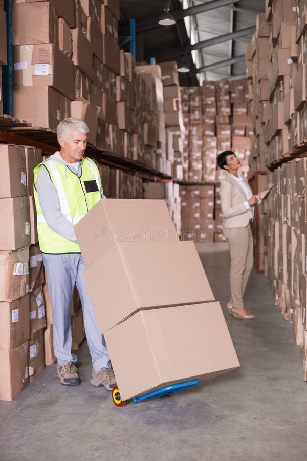 Warehouse Worker Moving Boxes on Trolley Stock Image - Image of ...
